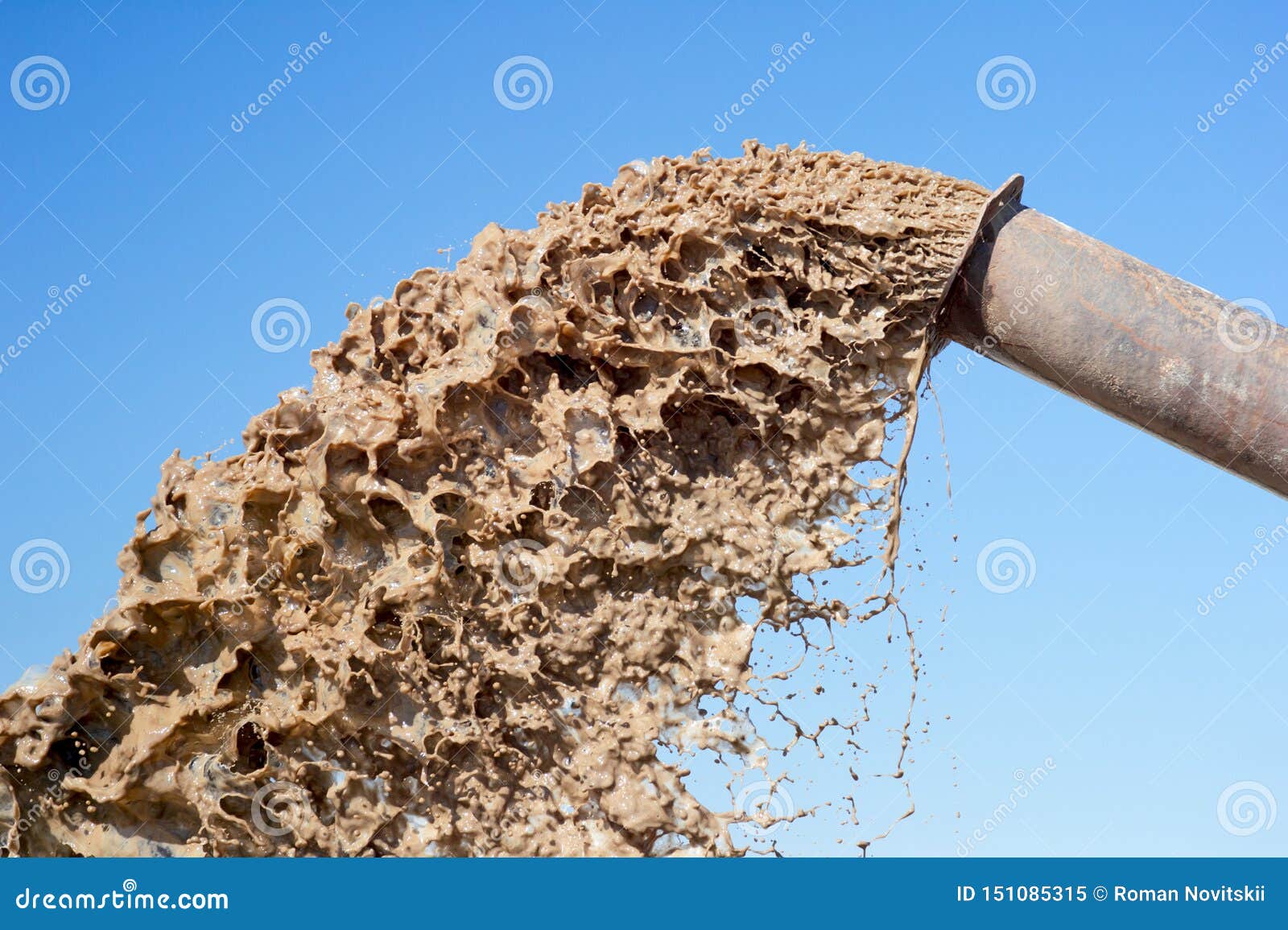 The Flow of Brown Liquid from the Pipe Against the Blue Clear Sky ...