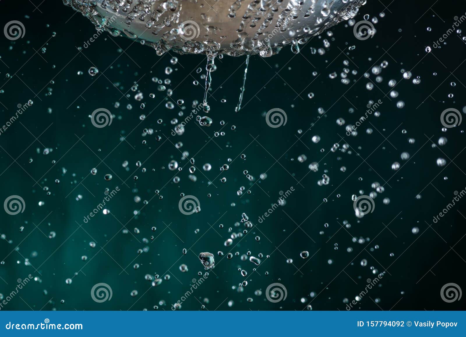 Flow and Drops of Water through Holes in a Colander on a Dark ...