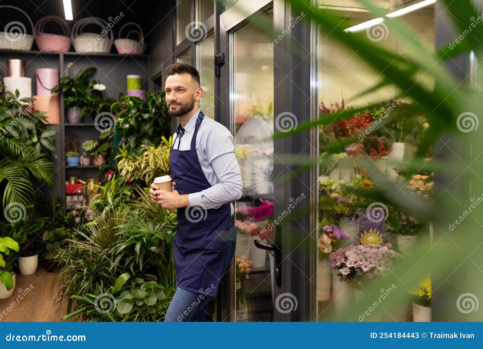 Flower Shop Employee Resting between Orders Leaning on the Refrigerator ...