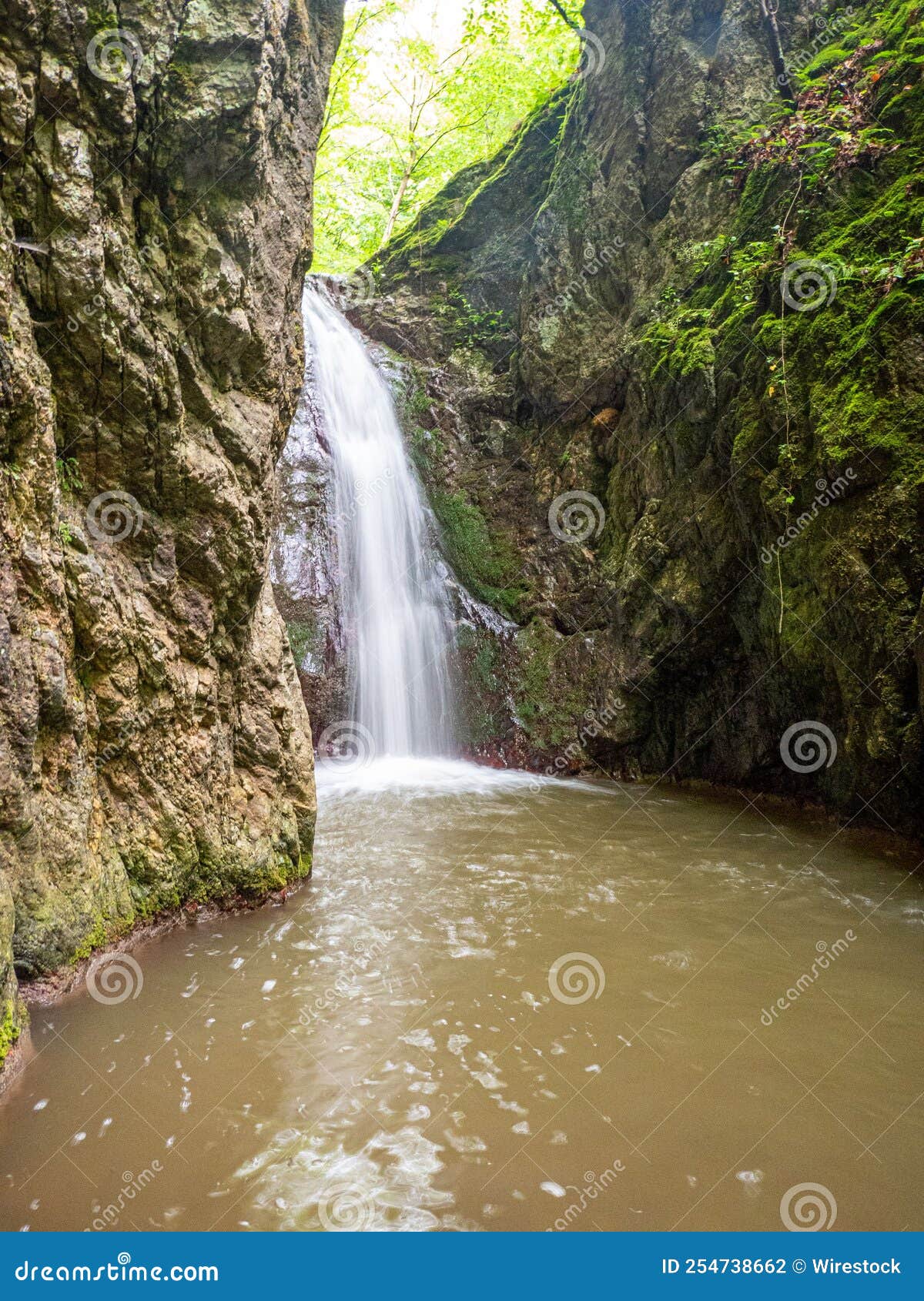 Flowing Waterfall Falling from Rocks Surrounded by Cliffs Stock Photo ...