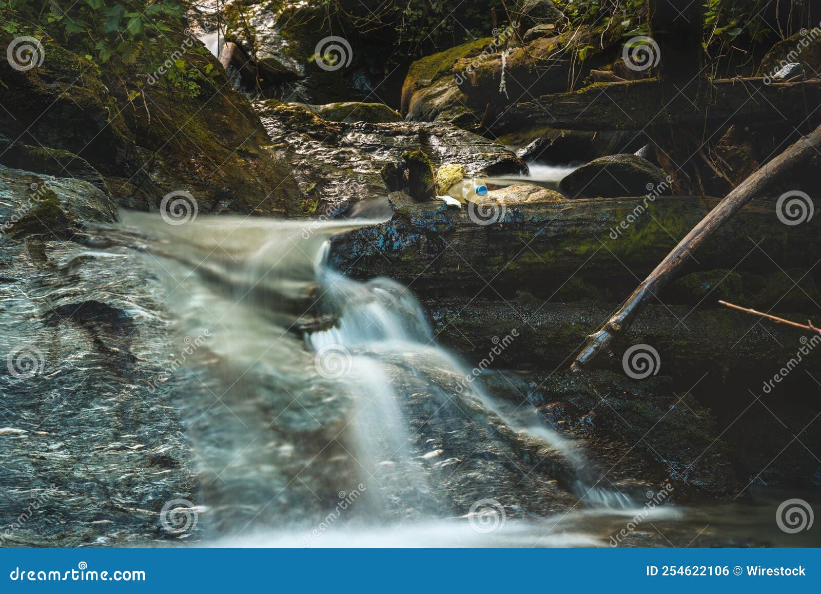 Flowing Waterfall with Plastic Bottle Washed Up on a Rock Stock Photo ...