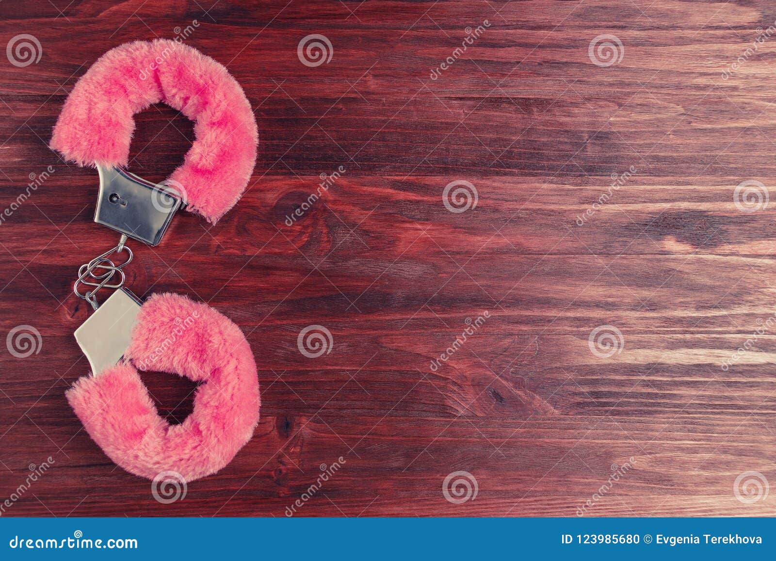 Fluffy Pink Handcuffs on a Dark Wooden Table Stock Photo - Image of ...