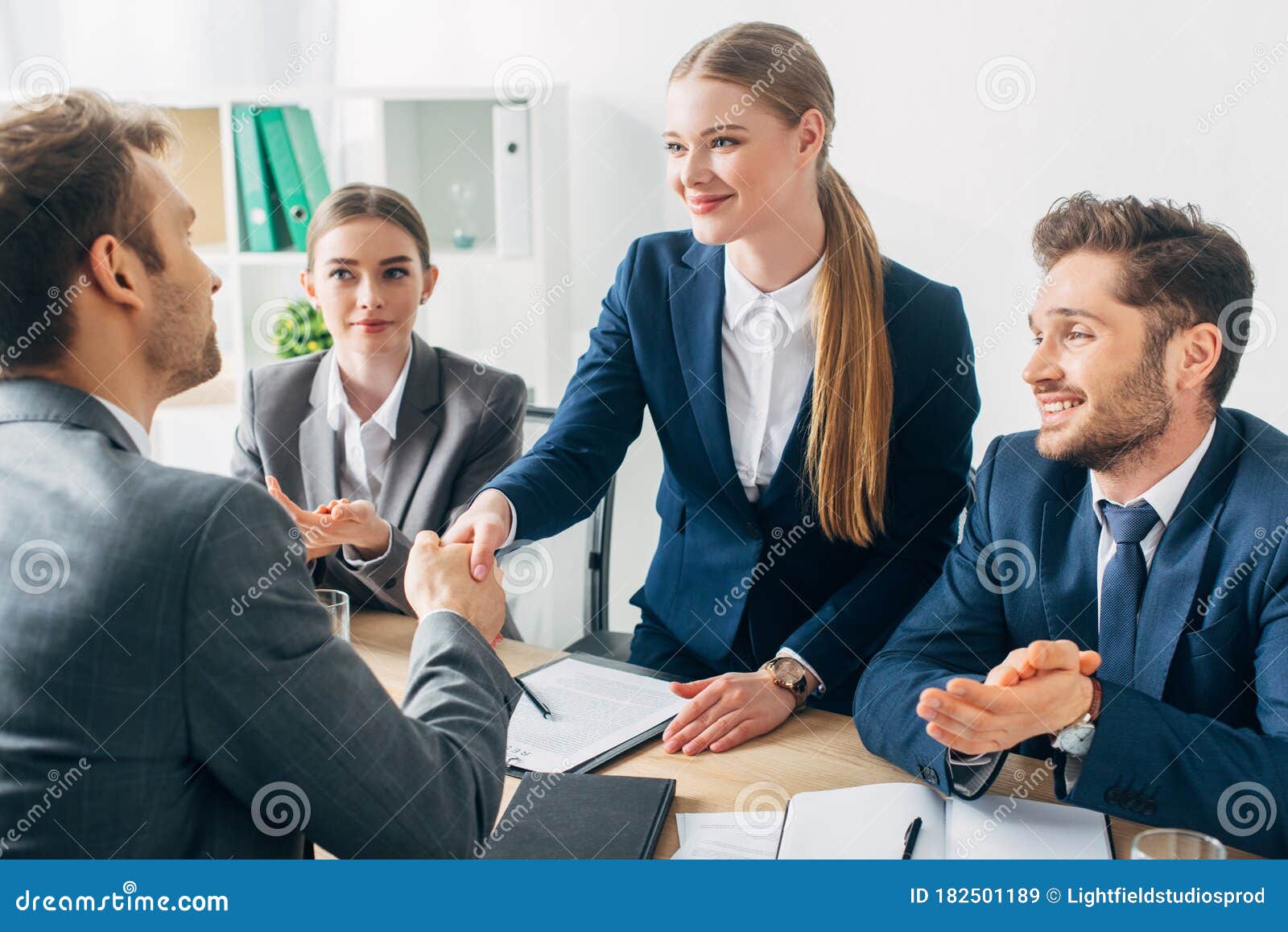 Focus of Smiling Recruiter Shaking Hands with Employee Near Colleagues ...