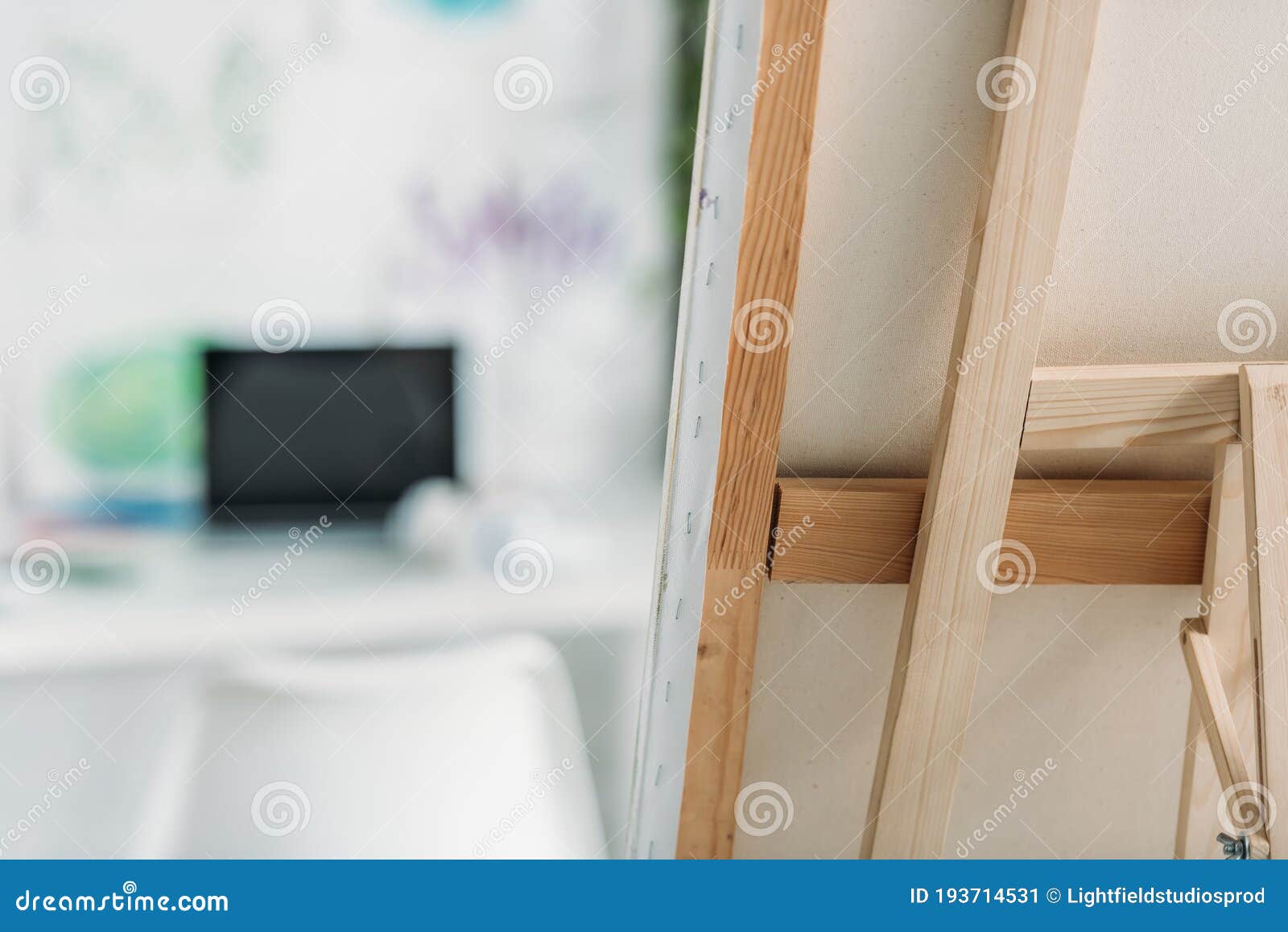 Focus of Wooden Easel with Fixed Canvas and Laptop with Blank Screen ...