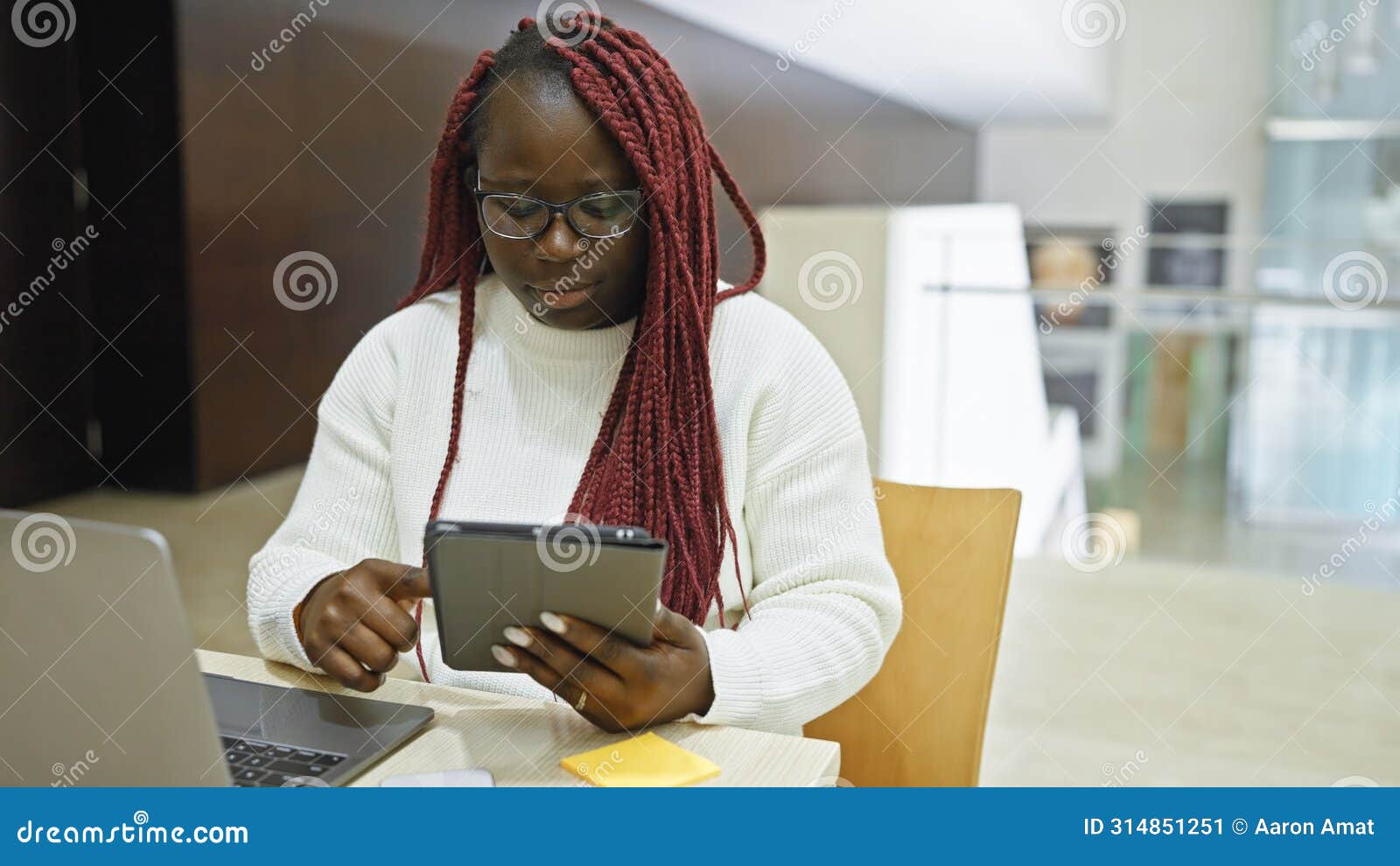 Focused African American Woman with Braids Using Tablet in Modern ...