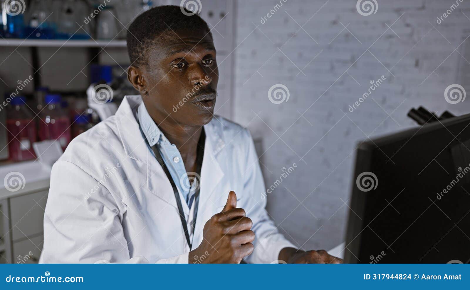 Focused African Man Wearing Lab Coat Working at Computer in a Modern ...