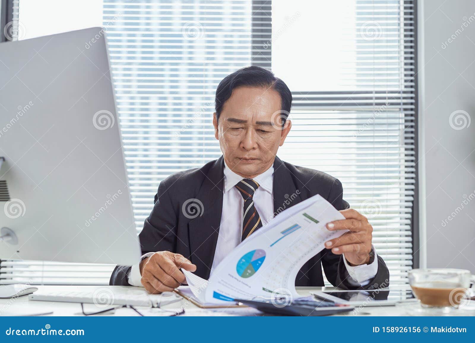 Focused Asian Businessman Working on Document in Office Stock Photo ...