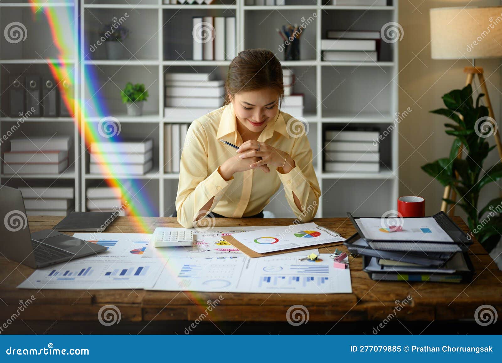 Focused Asian Female Accountant Analyzing Financial Graphs, Reports and ...