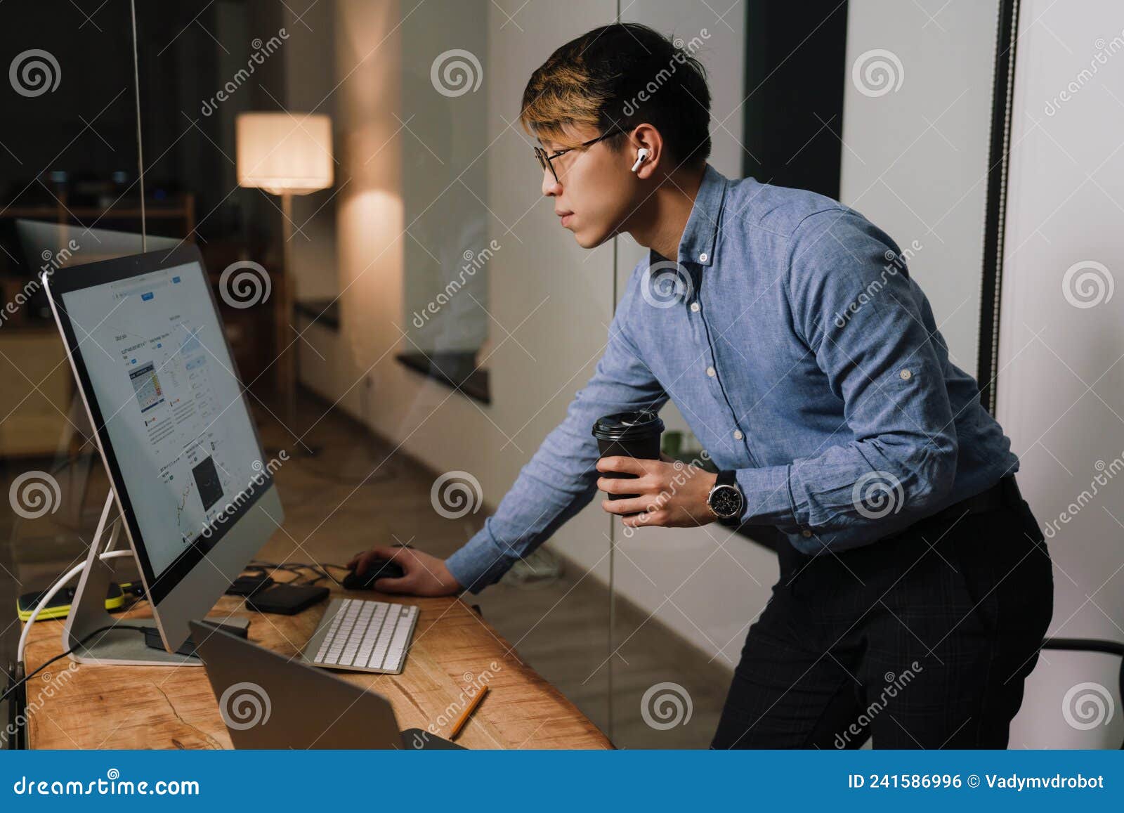 Focused Asian Guy Drinking Coffee while Working with Computers Stock ...