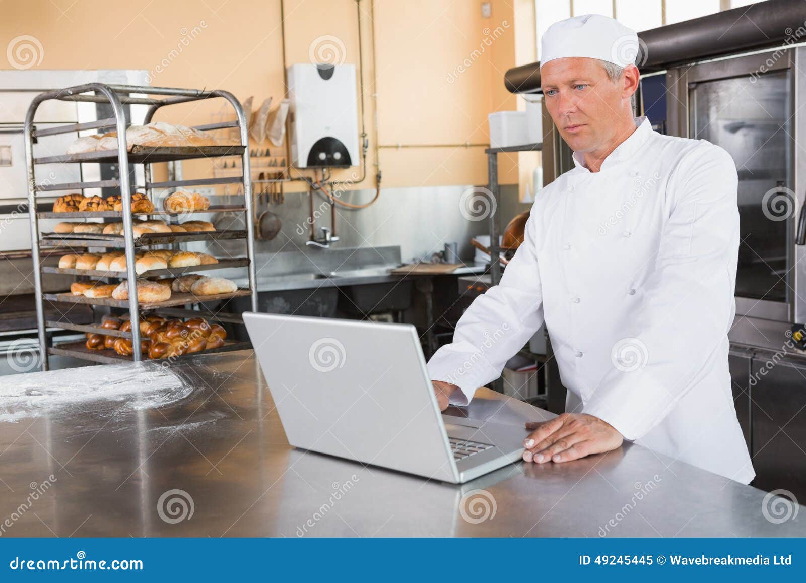 Focused Baker Using Laptop on Worktop Stock Image - Image of caucasian ...