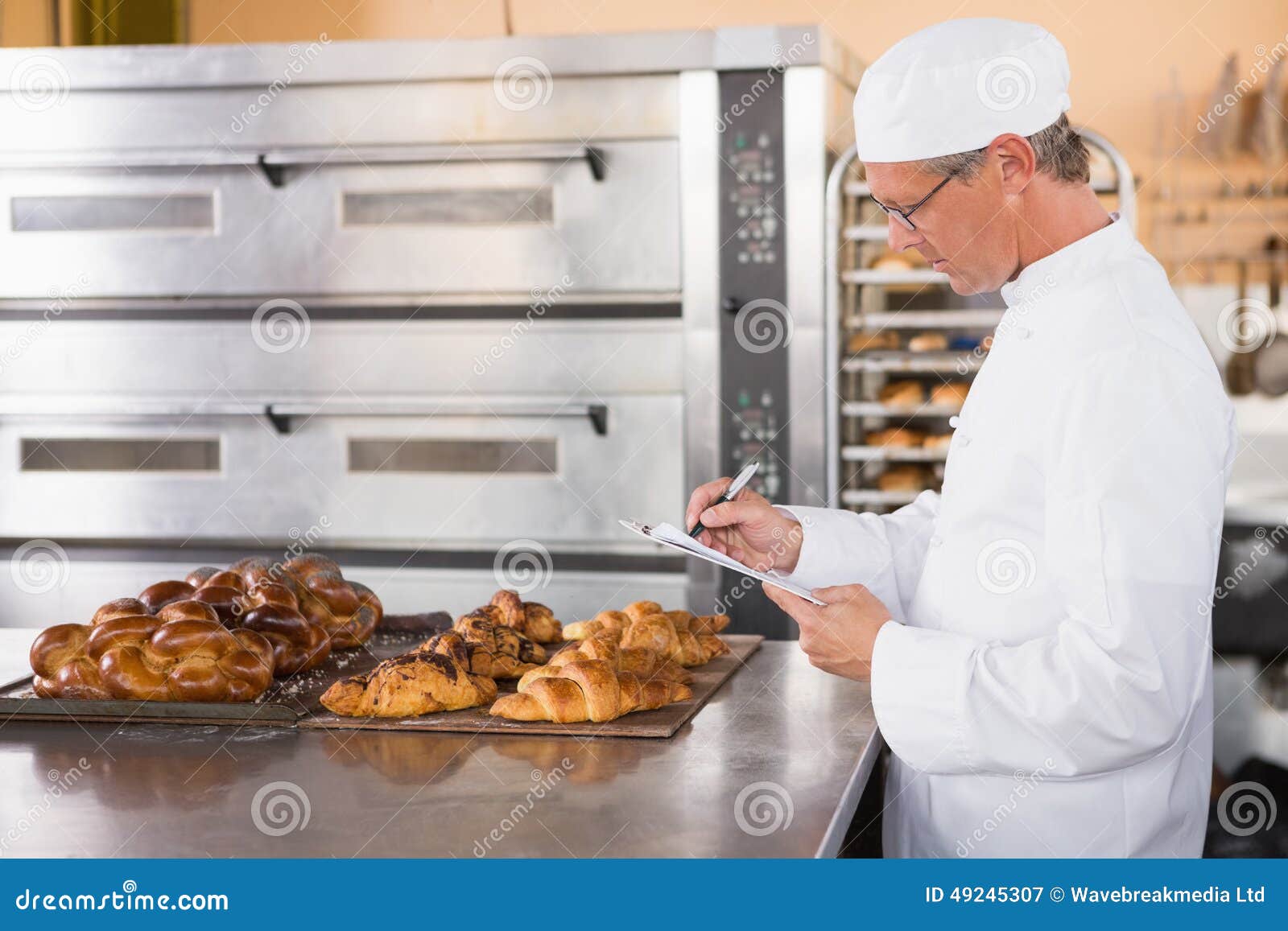 Focused Baker Writing on Clipboard Stock Image - Image of noting, male ...