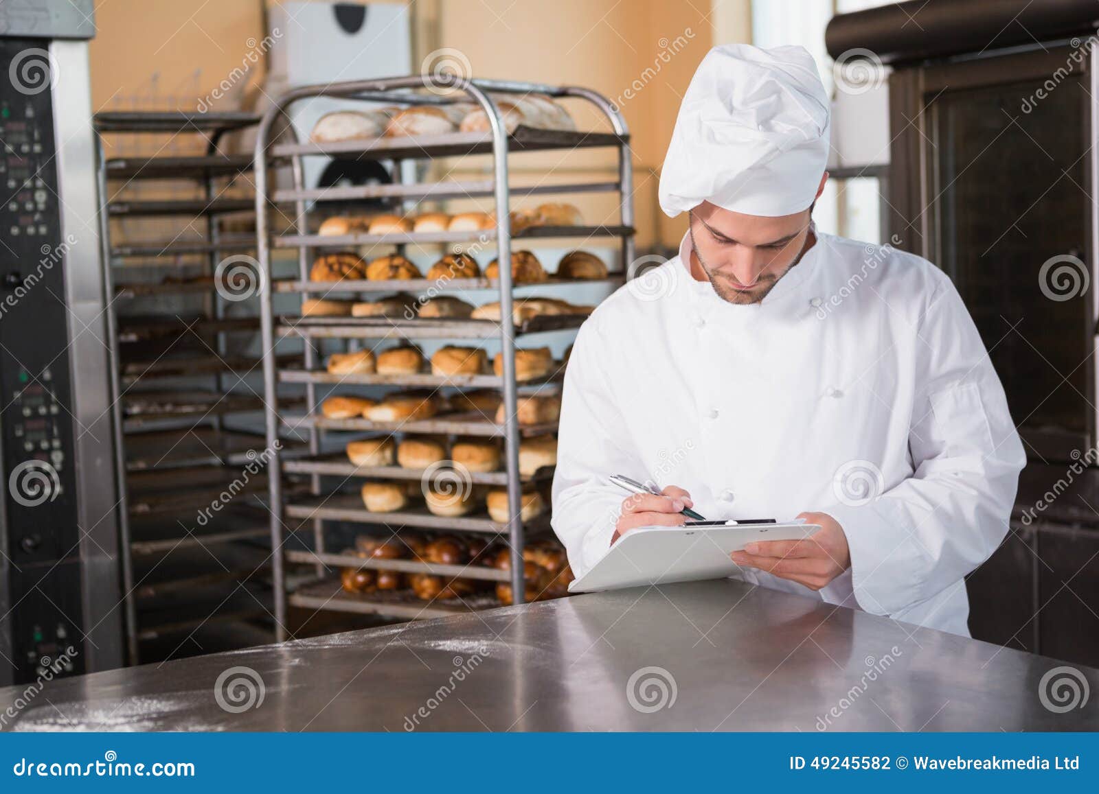 Focused Baker Writing on Clipboard Stock Photo - Image of profession ...