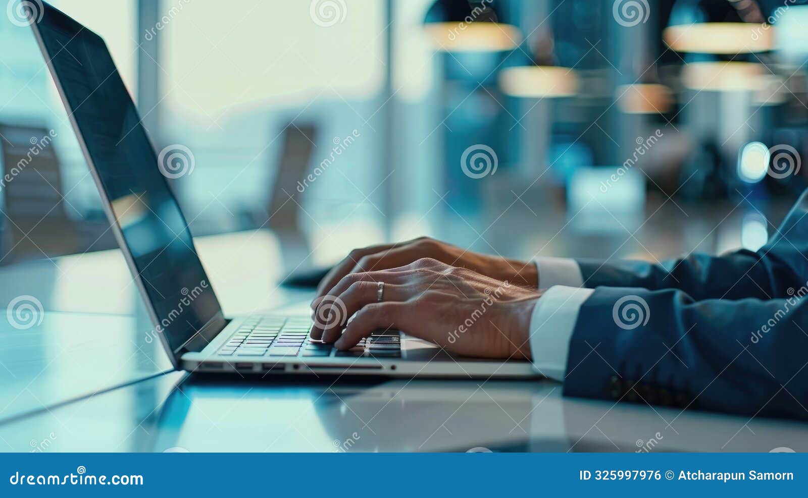 Focused Business Professional Typing on Laptop in Modern Office Setting ...