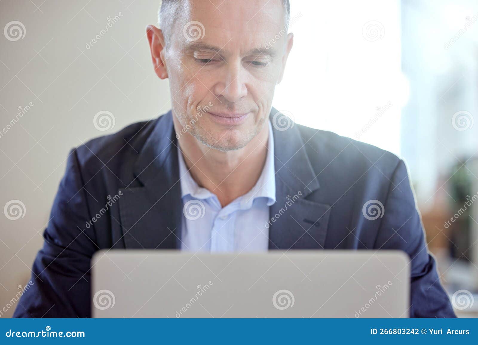 A Focused Businessman. a Mature Businessman Using a Laptop in an Office ...