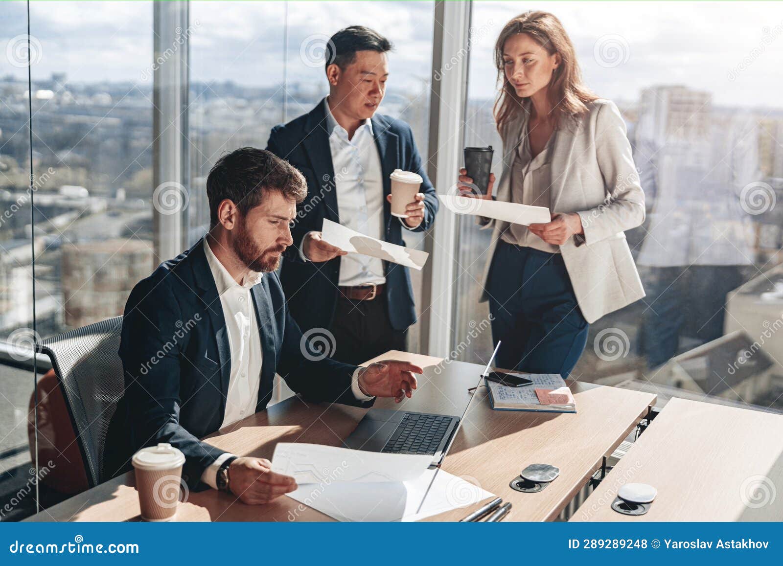 Focused Businessmen Drink Coffee and Discussing Documents with Graphs ...