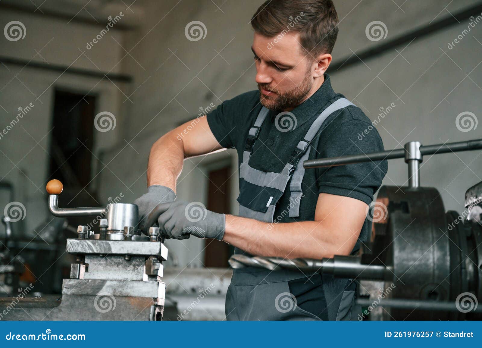 Focused on the Developing the Parts. Man in Uniform is in Workstation ...