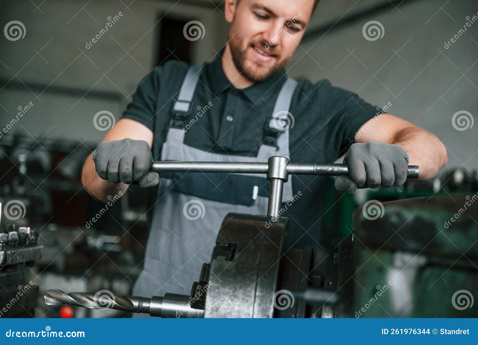 Focused on the Developing the Parts. Man in Uniform is in Workstation ...