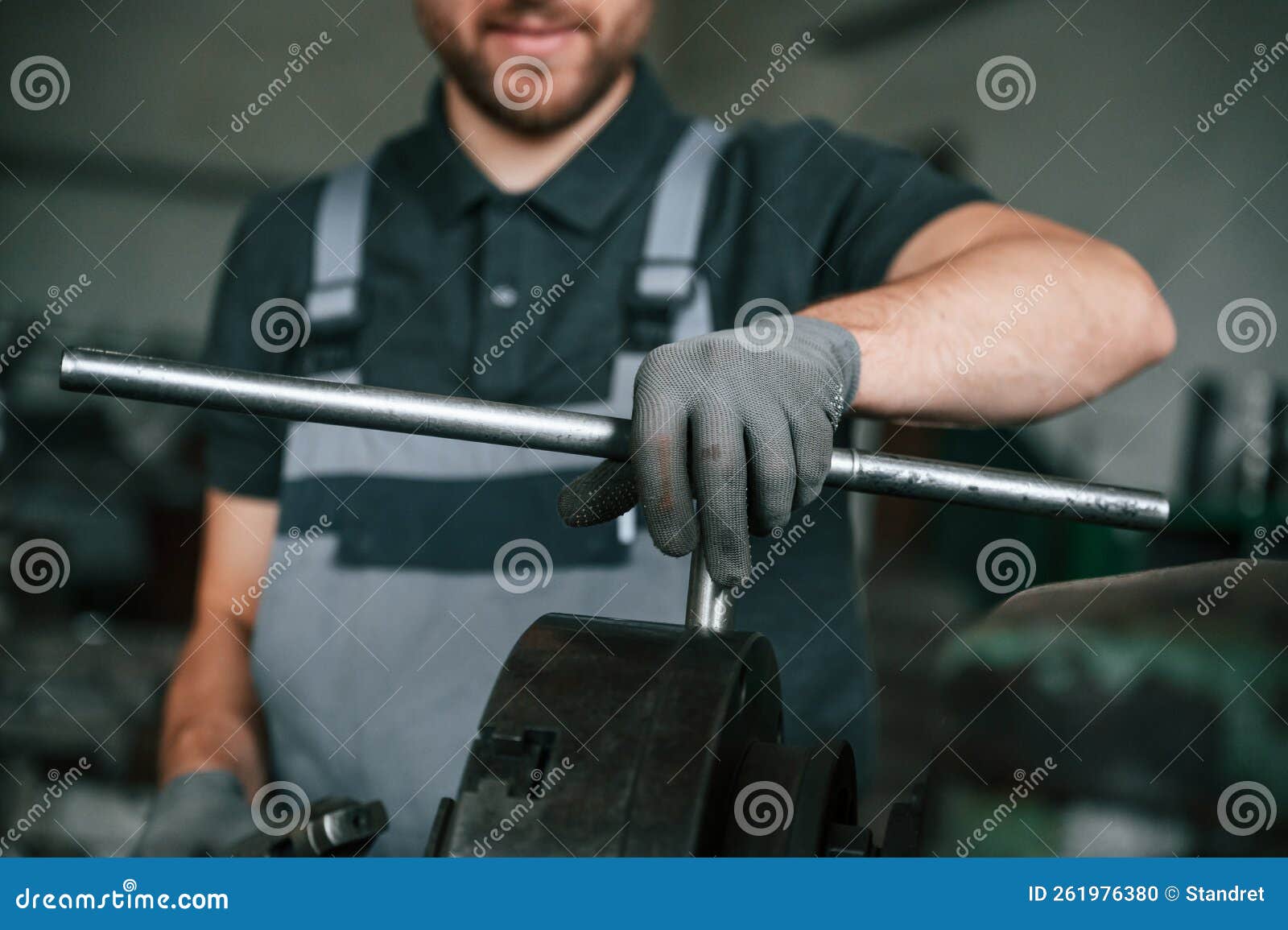 Focused on the Developing the Parts. Man in Uniform is in Workstation ...