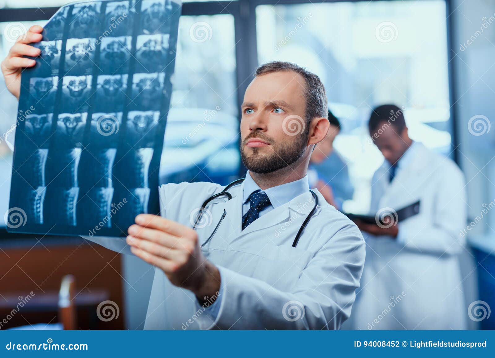 Focused Doctor Analyzing X-ray Picture with Colleagues Behind Stock ...