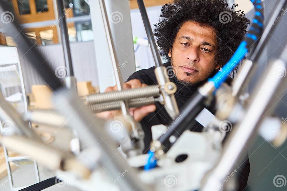 Engineer Programming a Robotic Gripper Arm for Industrial Automation in a Modern Laboratory ...