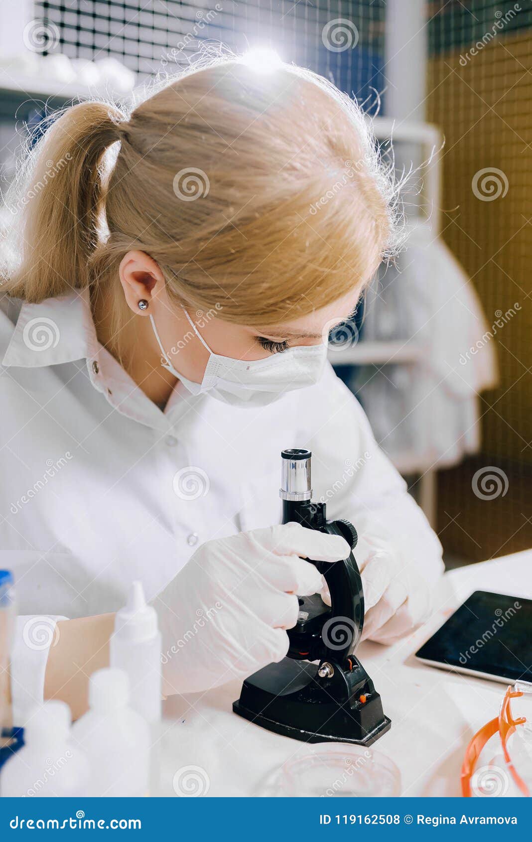 Focused Female Science Student Looking in a Microscope in a Laboratory ...