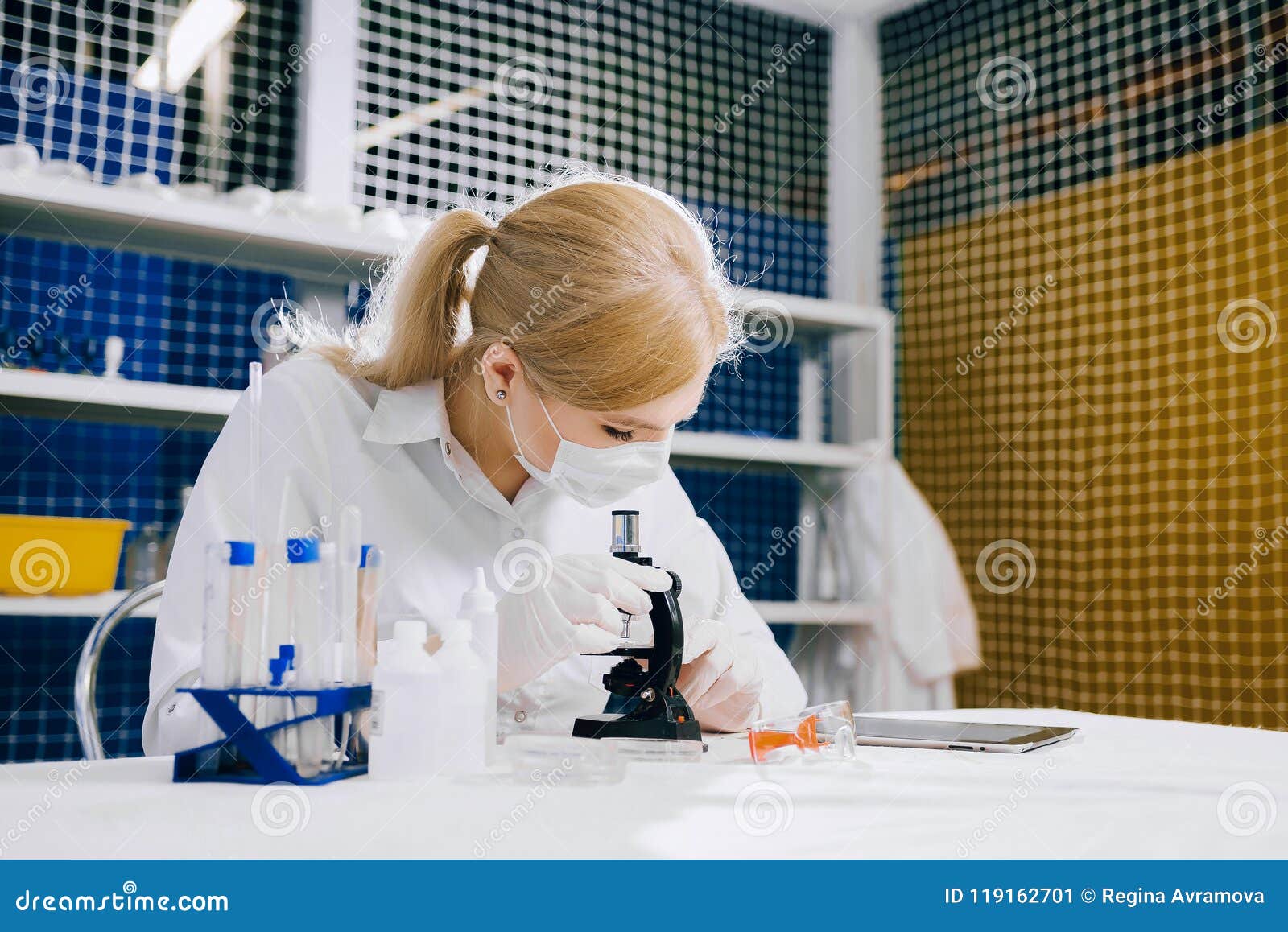 Focused Female Science Student Looking in a Microscope in a Laboratory ...