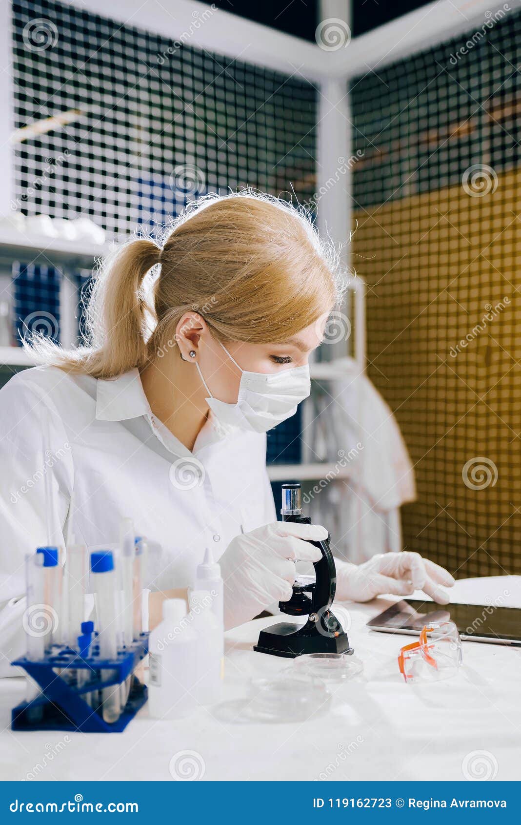Focused Female Science Student Looking in a Microscope in a Laboratory ...