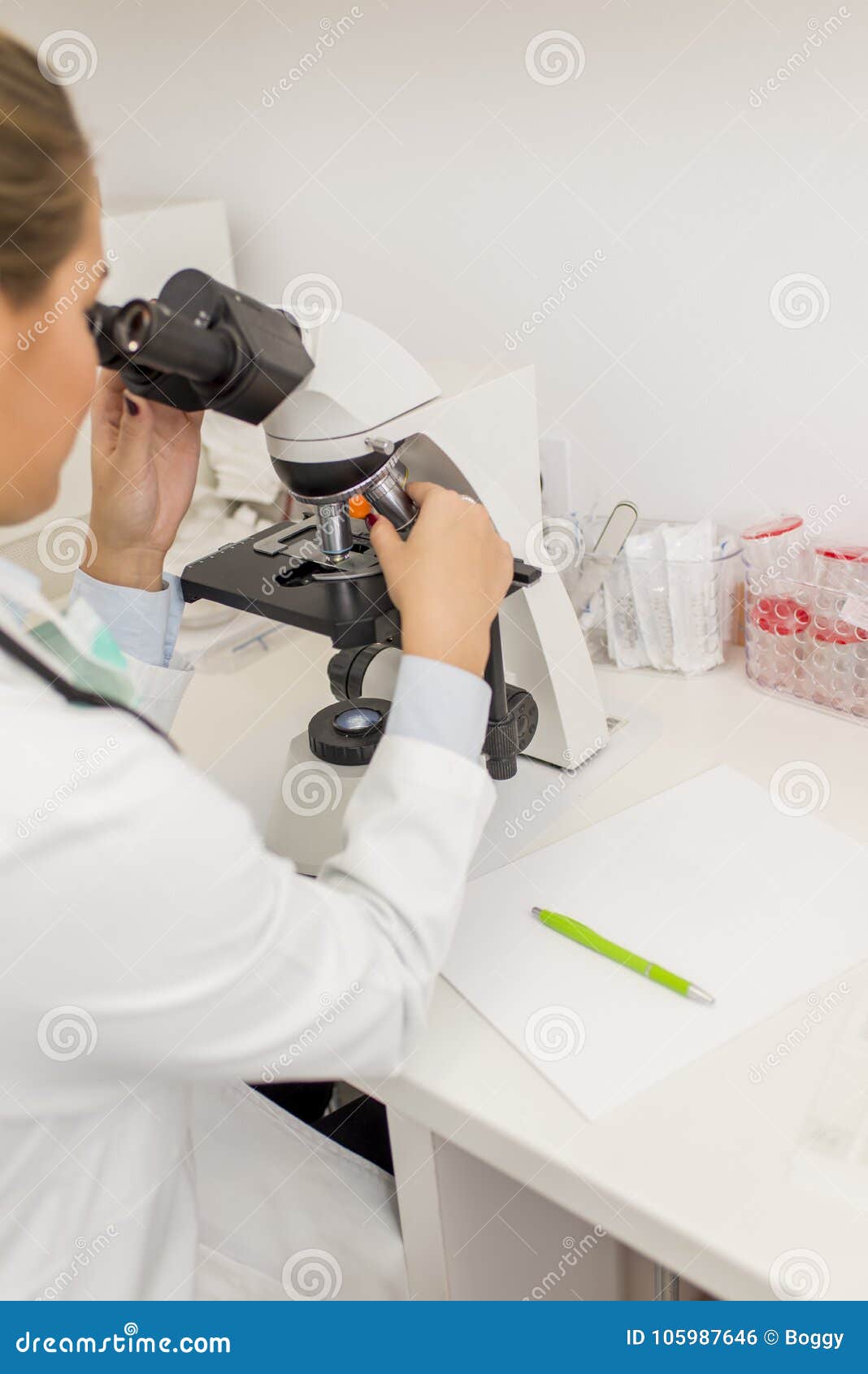 Focused Female Science Student Looking in a Microscope in a Laboratory ...