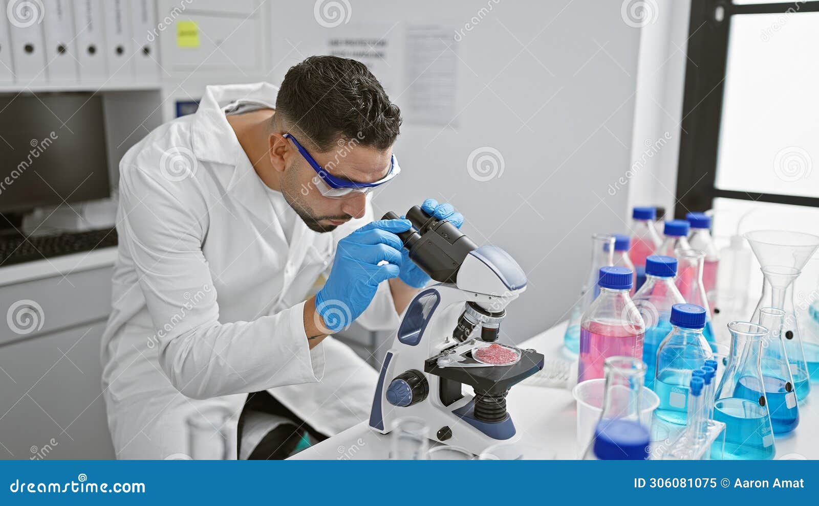 A Focused Man Examining Samples Under a Microscope in a Modern ...