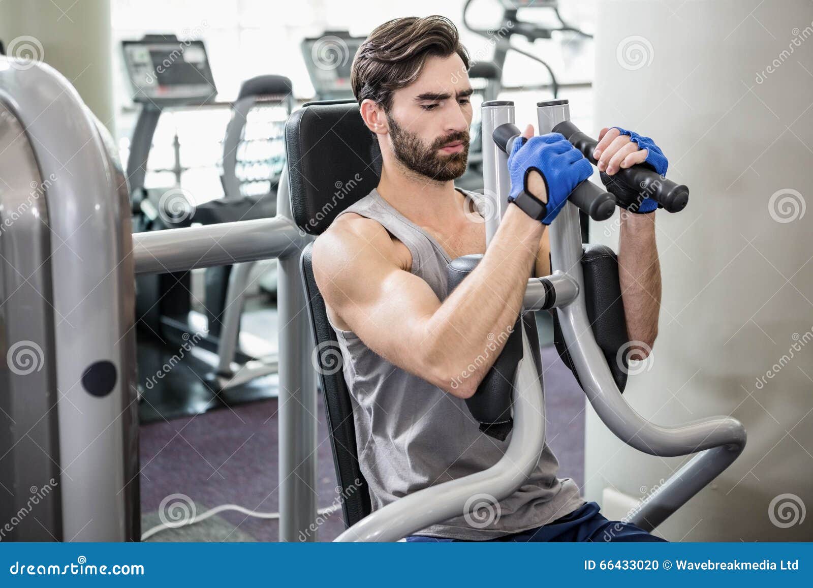 Focused Man Using Weights Machine for Arms Stock Photo - Image of ...