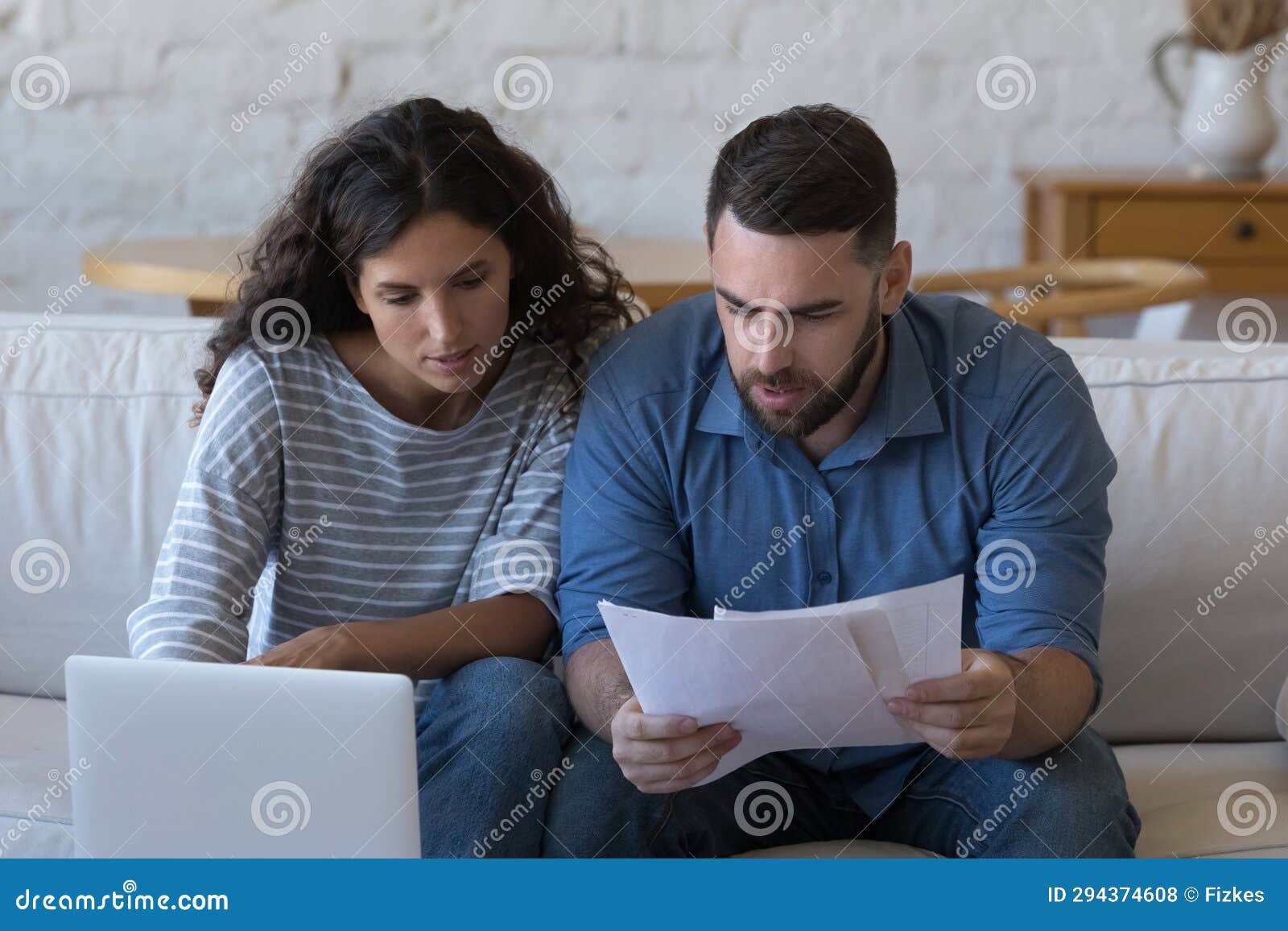 Focused Married Couple Reading Paper Documents at Laptop Stock Photo ...