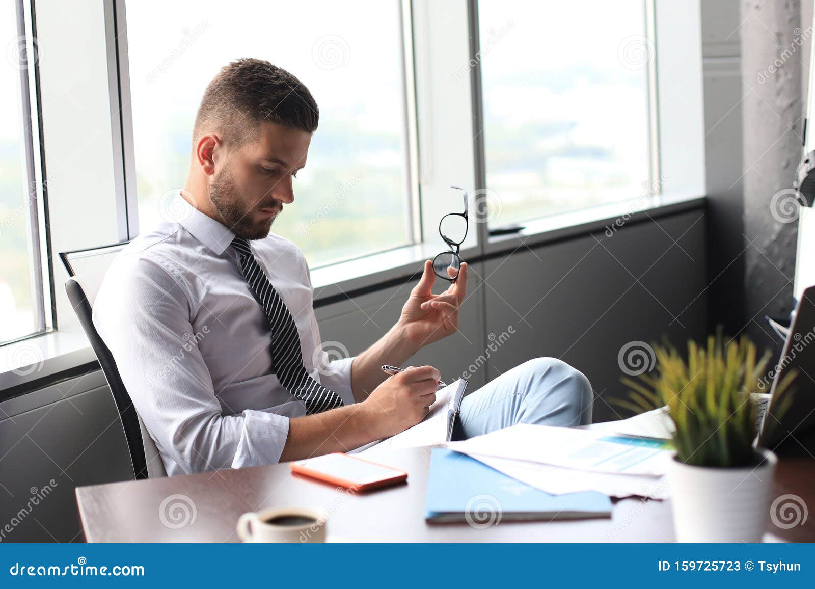 Focused Modern Businessman Working and Taking Notes in His Modern ...
