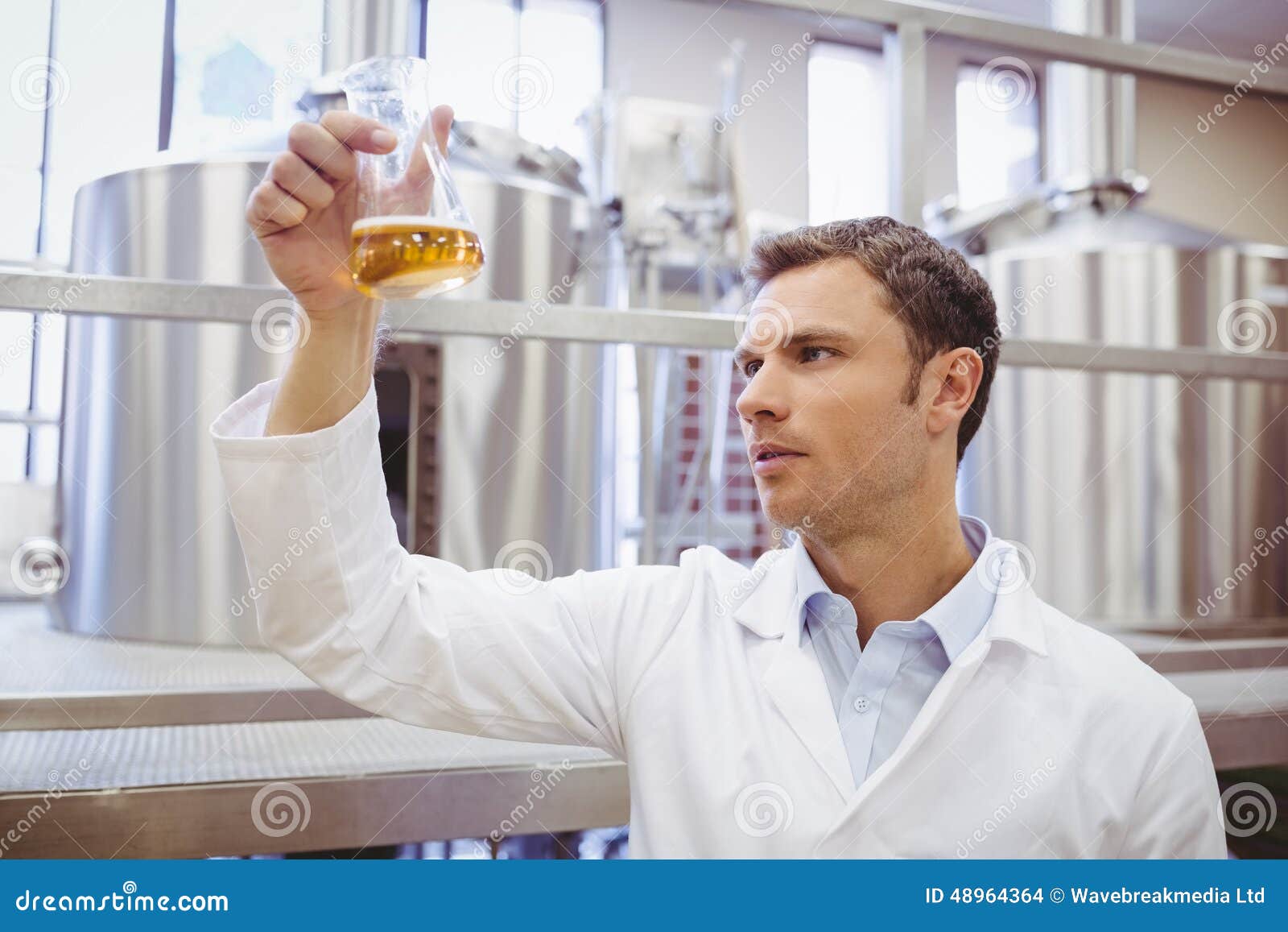 Focused Scientist Examining Beaker with Beer Stock Photo - Image of ...
