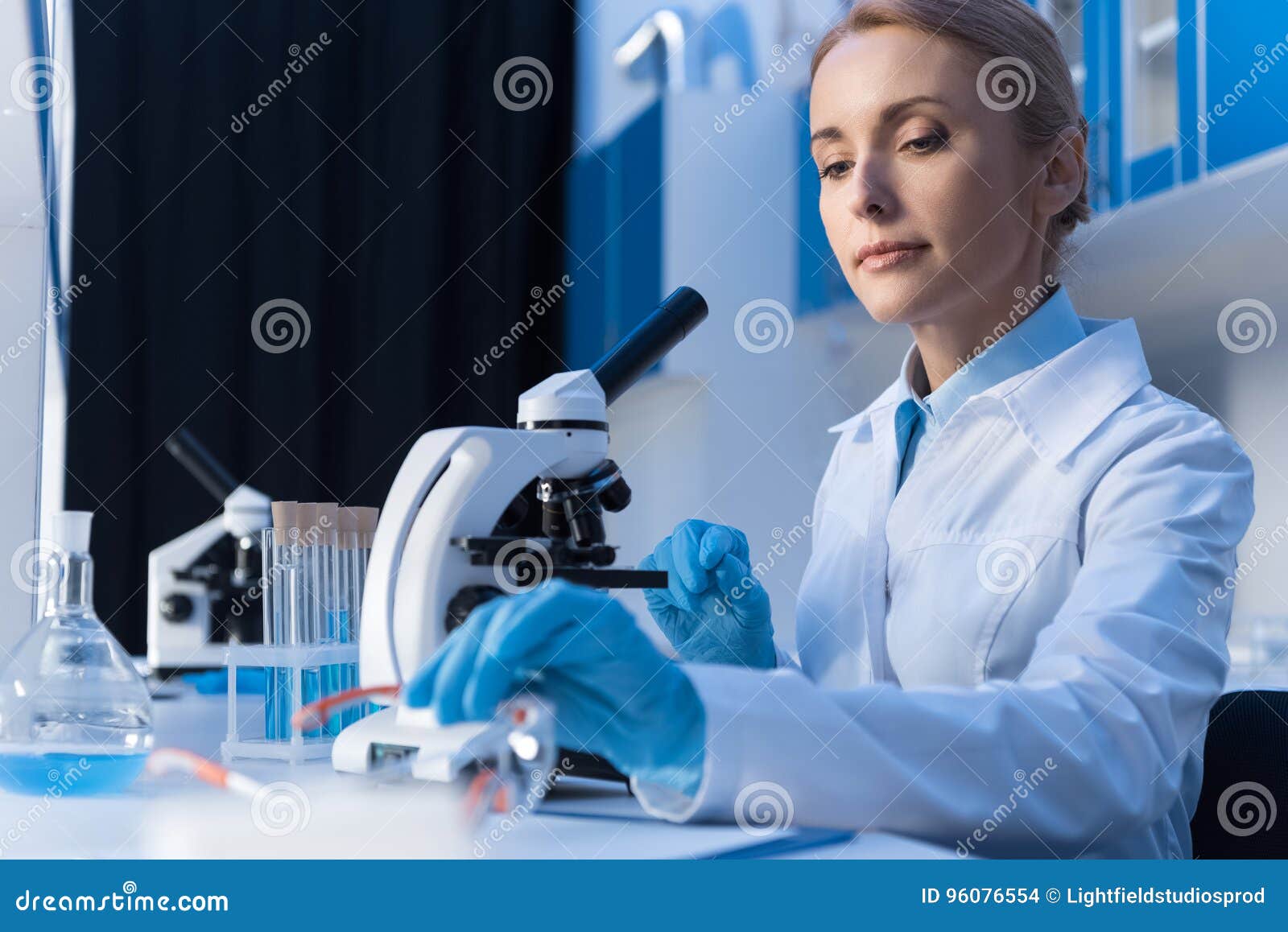 Focused Scientist Using Microscope while Working with Reagents in Lab ...