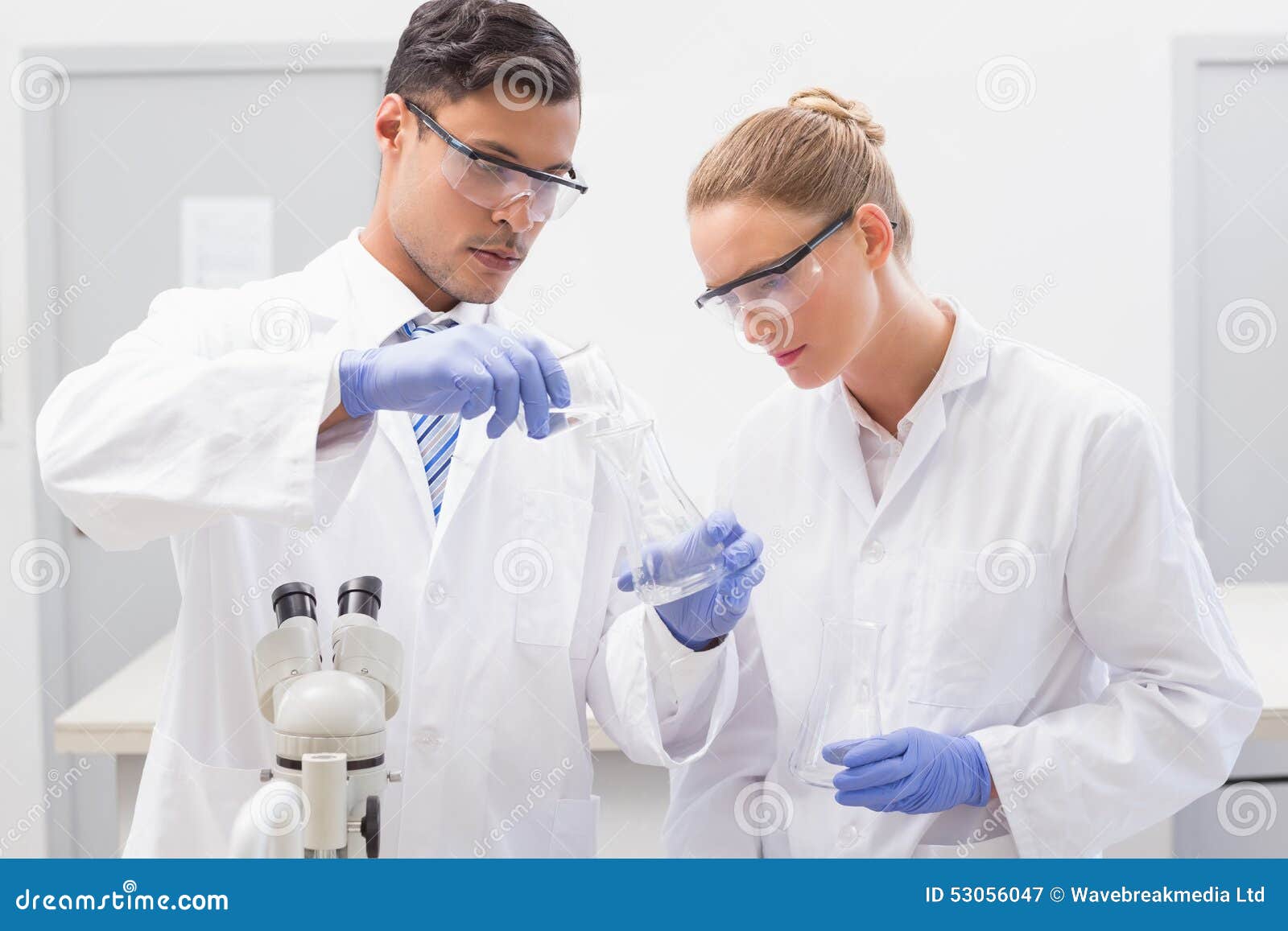 Focused Scientists Examining Beaker Stock Image - Image of male, people ...