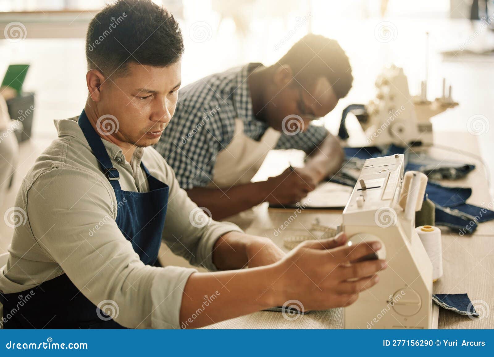 Focused Tailor Using a Sewing Machine. Young Designer Turning a Dial on ...