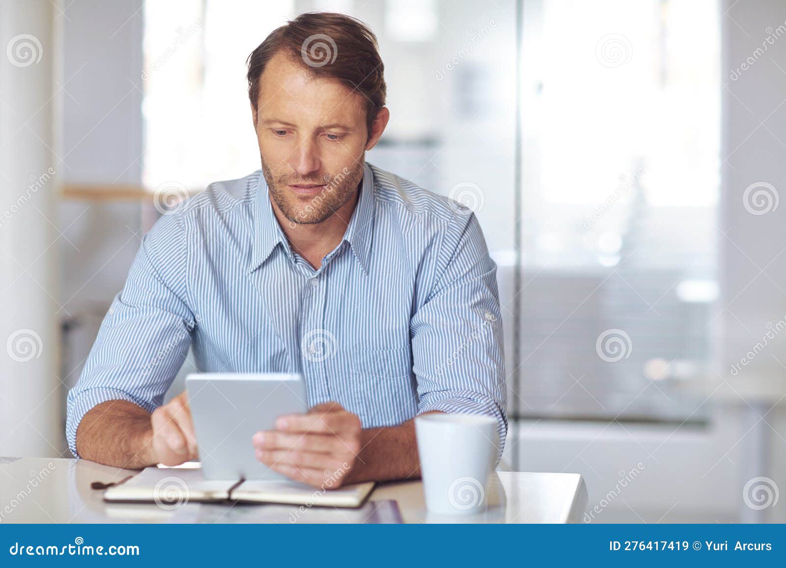 Focused on the Task at Hand. a Mature Businssman Using a Digital Tablet ...