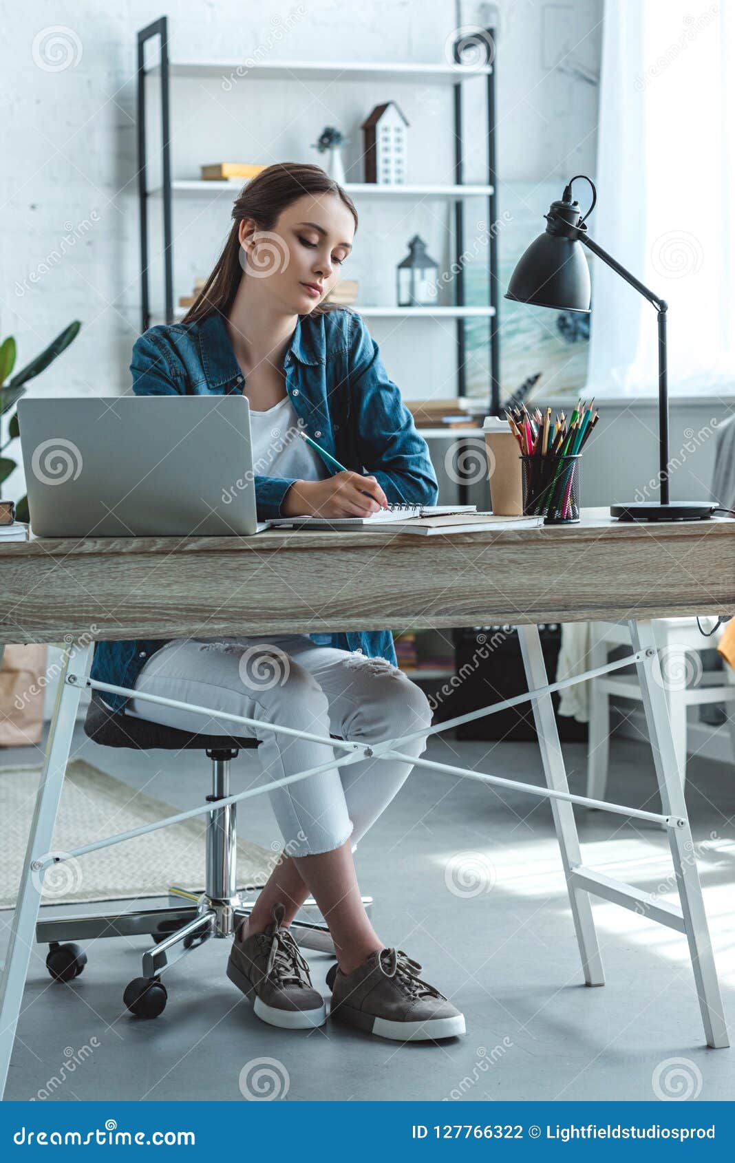 Focused Teenage Girl Taking Notes and Using Laptop while Studying Stock ...