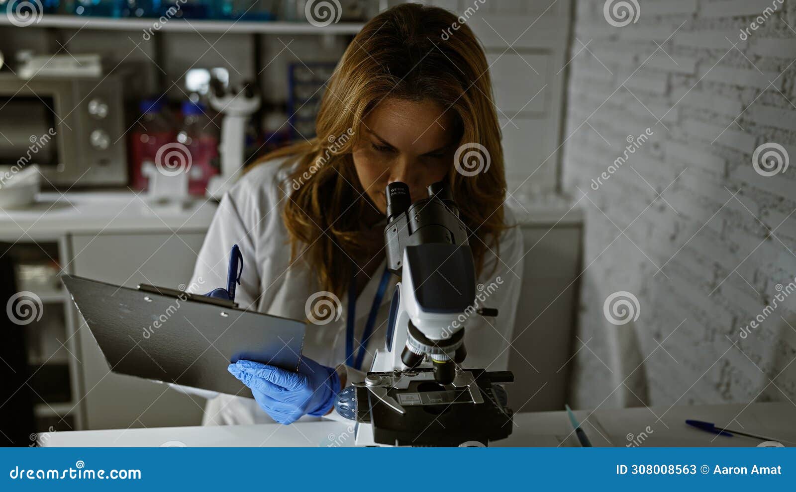 Focused Woman Scientist Using Microscope in Lab while Consulting Notes ...