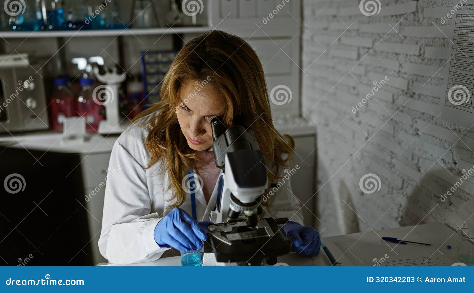 A Focused Woman Scientist Using a Microscope in a Laboratory Setting ...