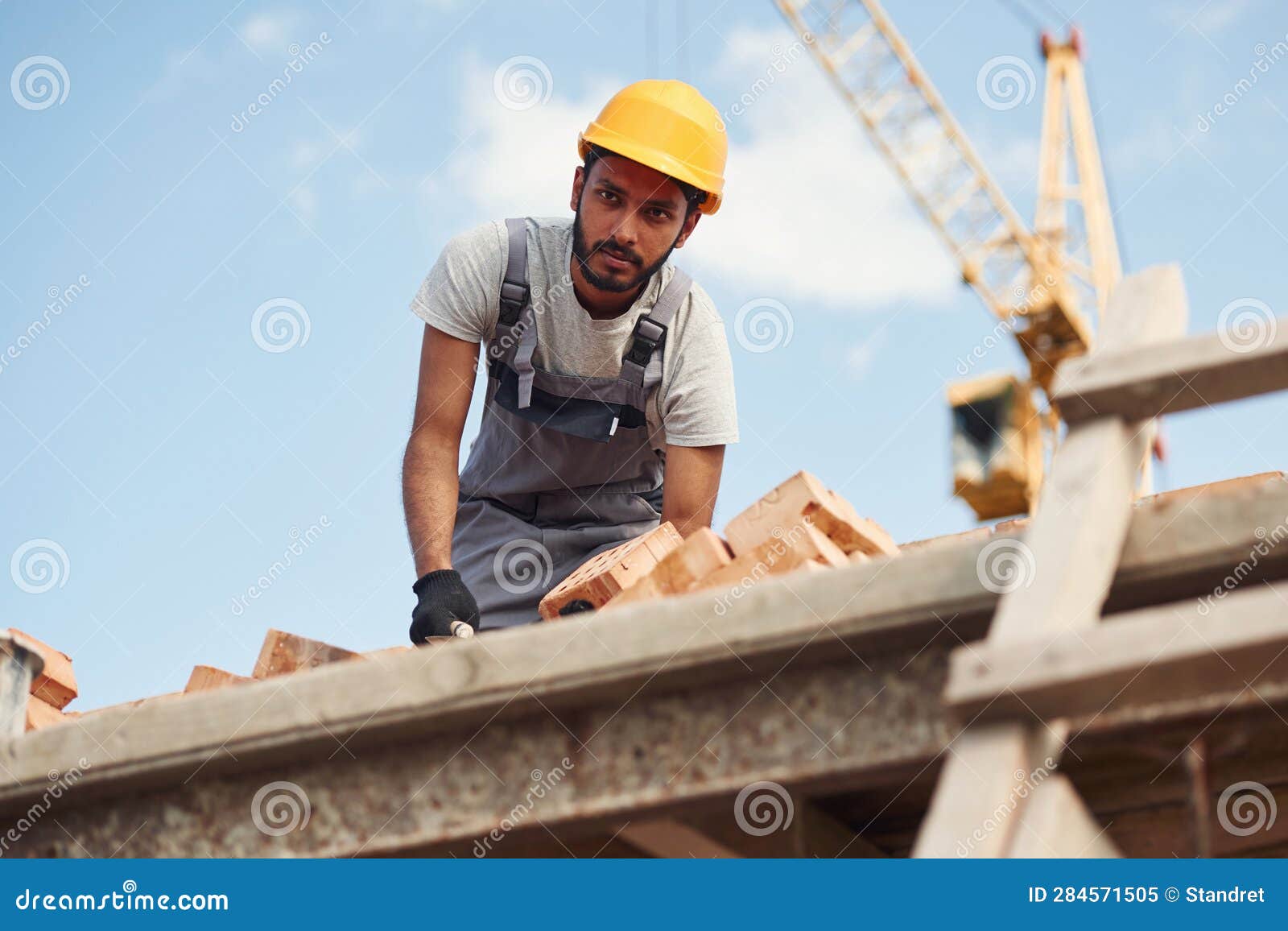 Showing and Holding Little Shovel and Brick. Handsome Indian Man is on ...