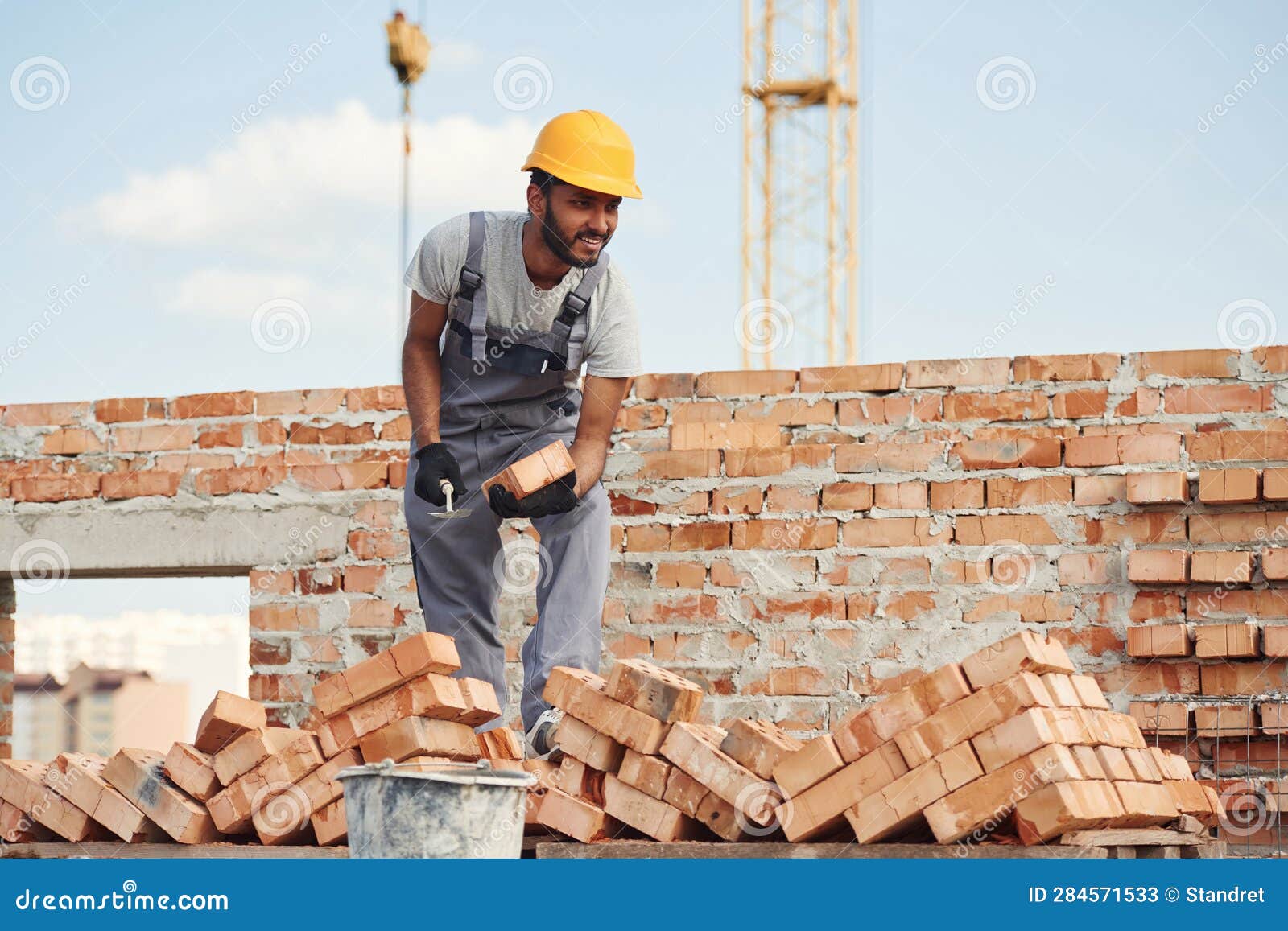 Showing and Holding Little Shovel and Brick. Handsome Indian Man is on ...
