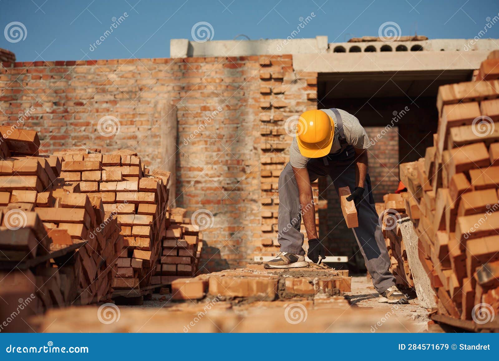 Showing and Holding Little Shovel and Brick. Handsome Indian Man is on ...
