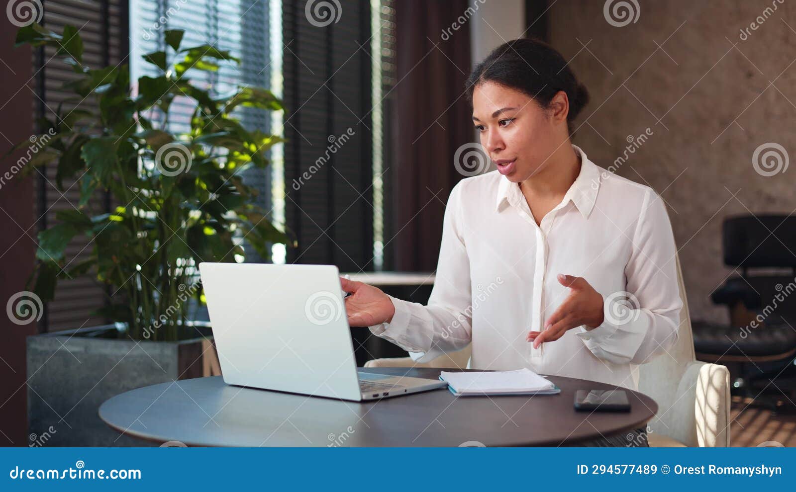 Focused Worker Talking on Video Call and Writing Information Stock ...