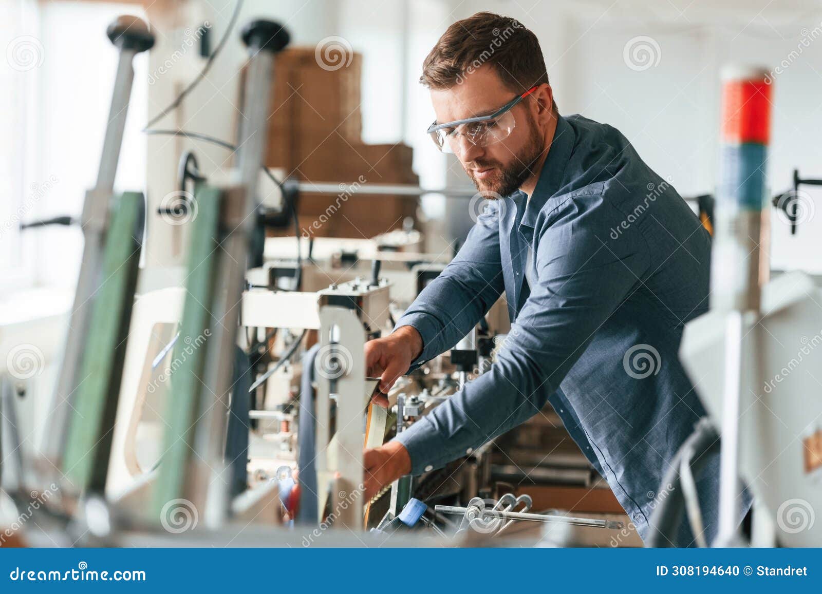 Focused by Working with Machine. Handsome Man is at the Factory of ...