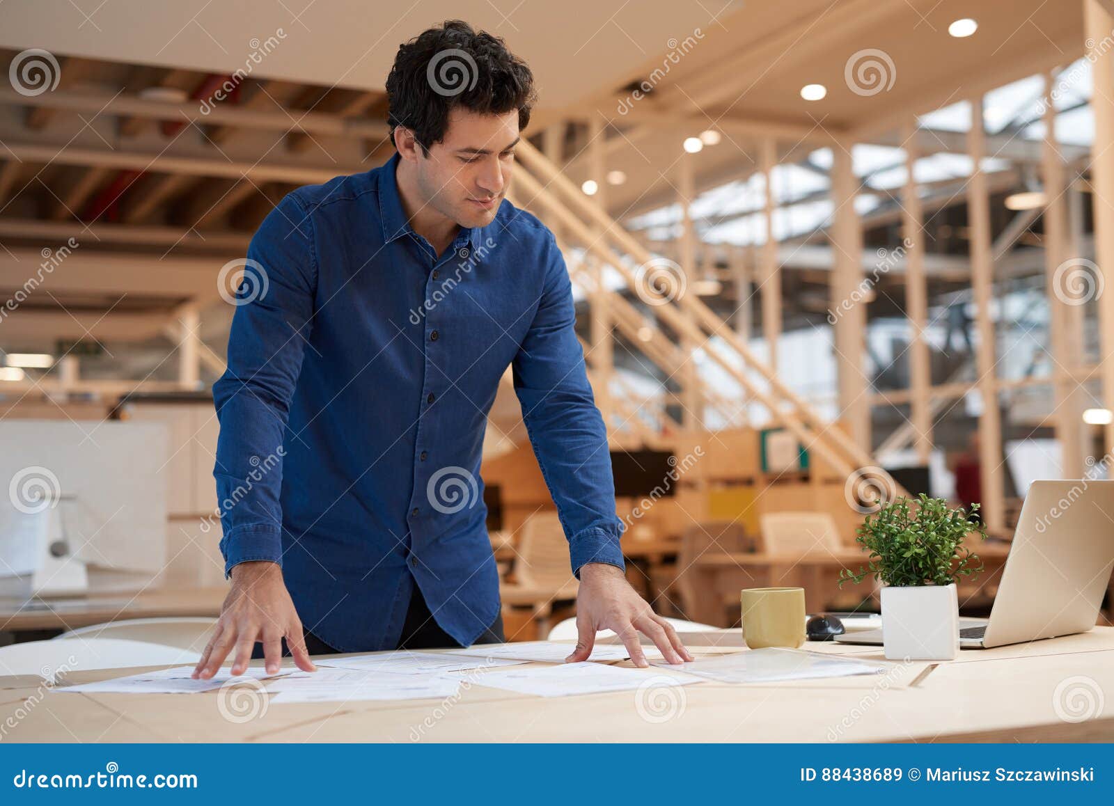 Focused Young Businessman Standing Over an Office Table Reading ...