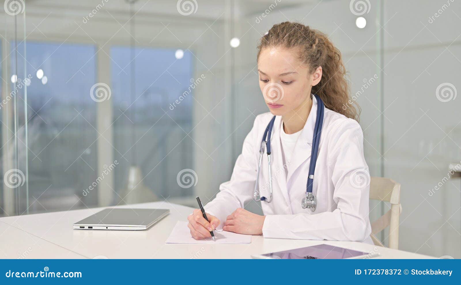 Focused Young Doctor Doing Paperwork in Modern Office Stock Photo ...