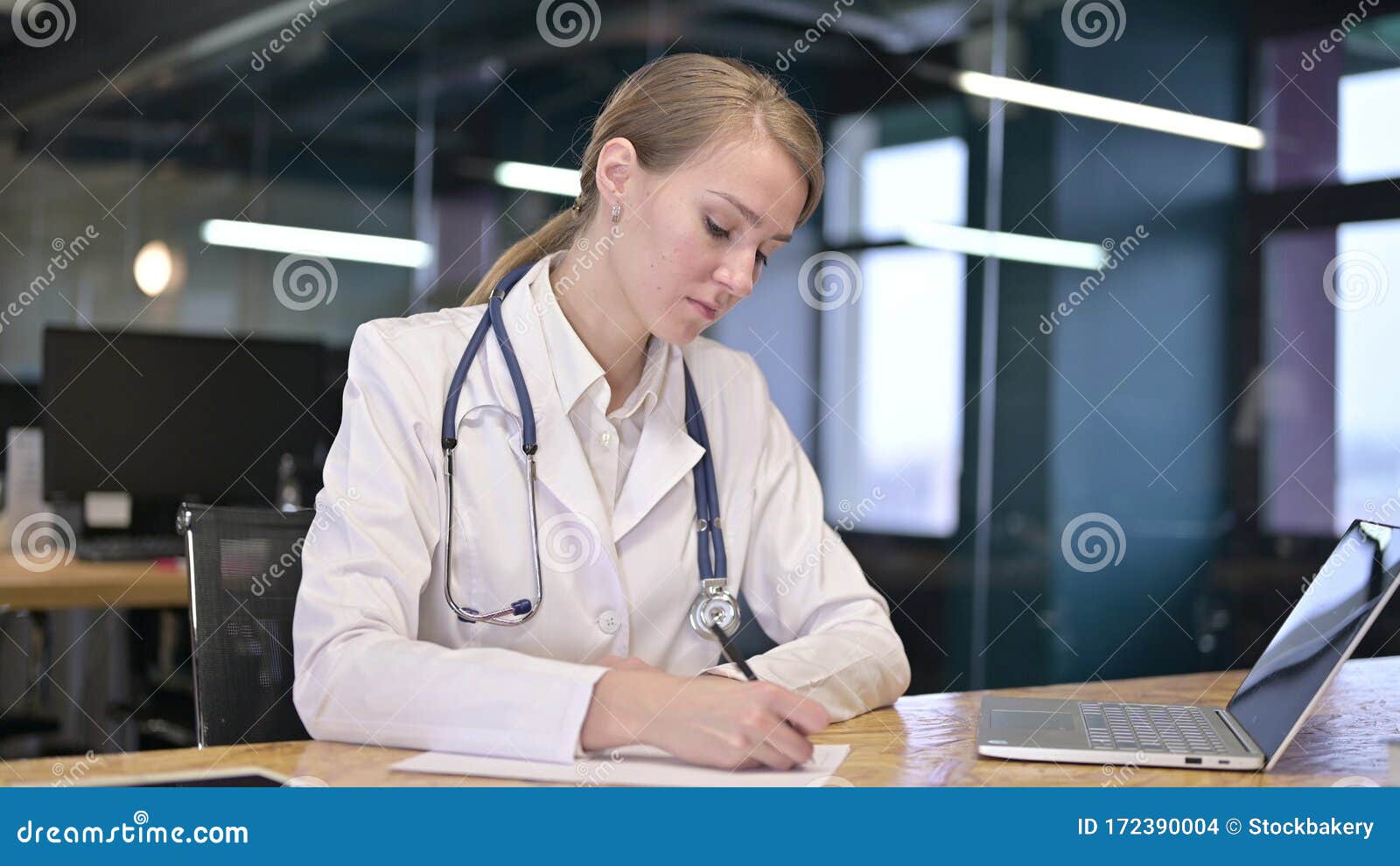 Focused Young Doctor Doing Paperwork in Modern Office Stock Photo ...