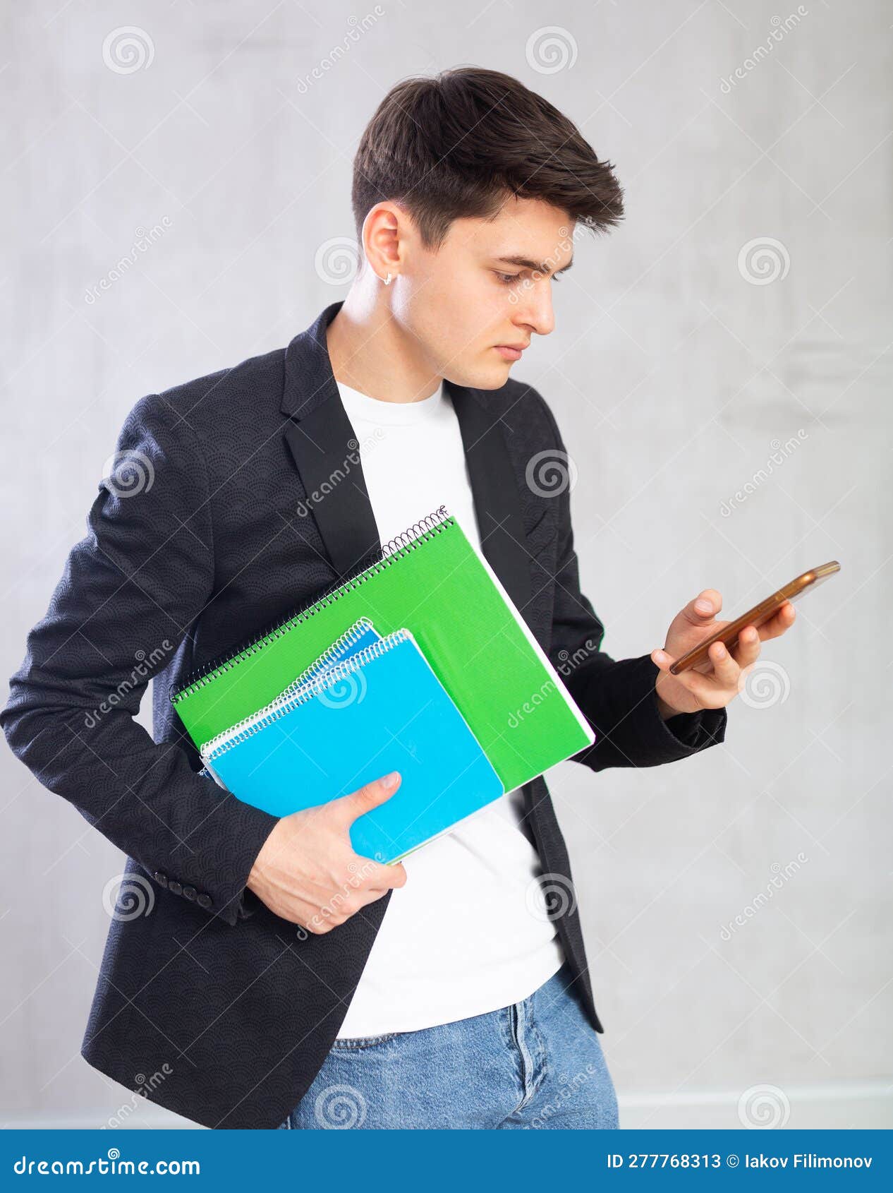 Focused Young Guy with Stack of Notebooks Holding Phone Stock Image ...