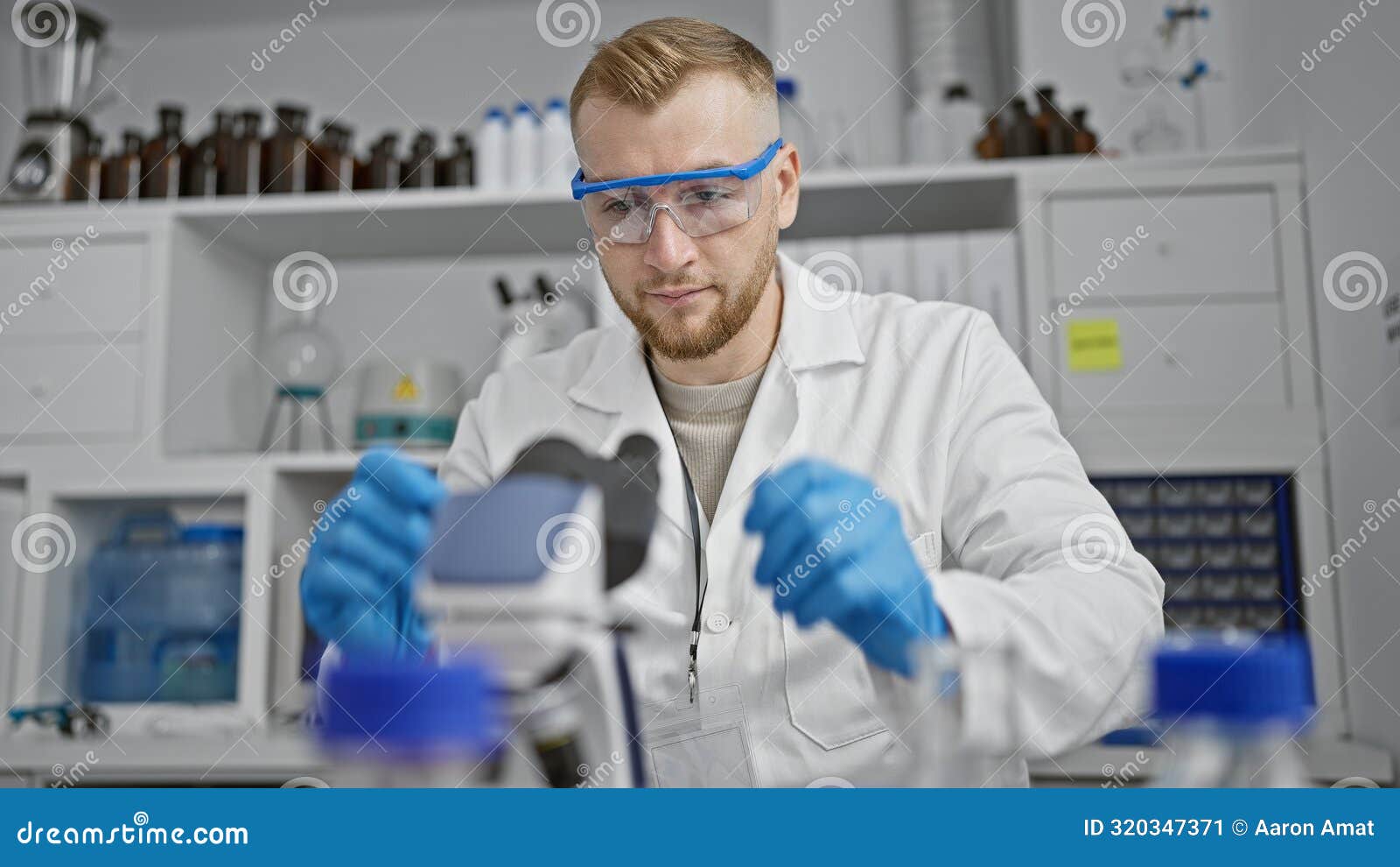 A Focused Young Man in Lab Coat Conducts Experiments in a Modern ...